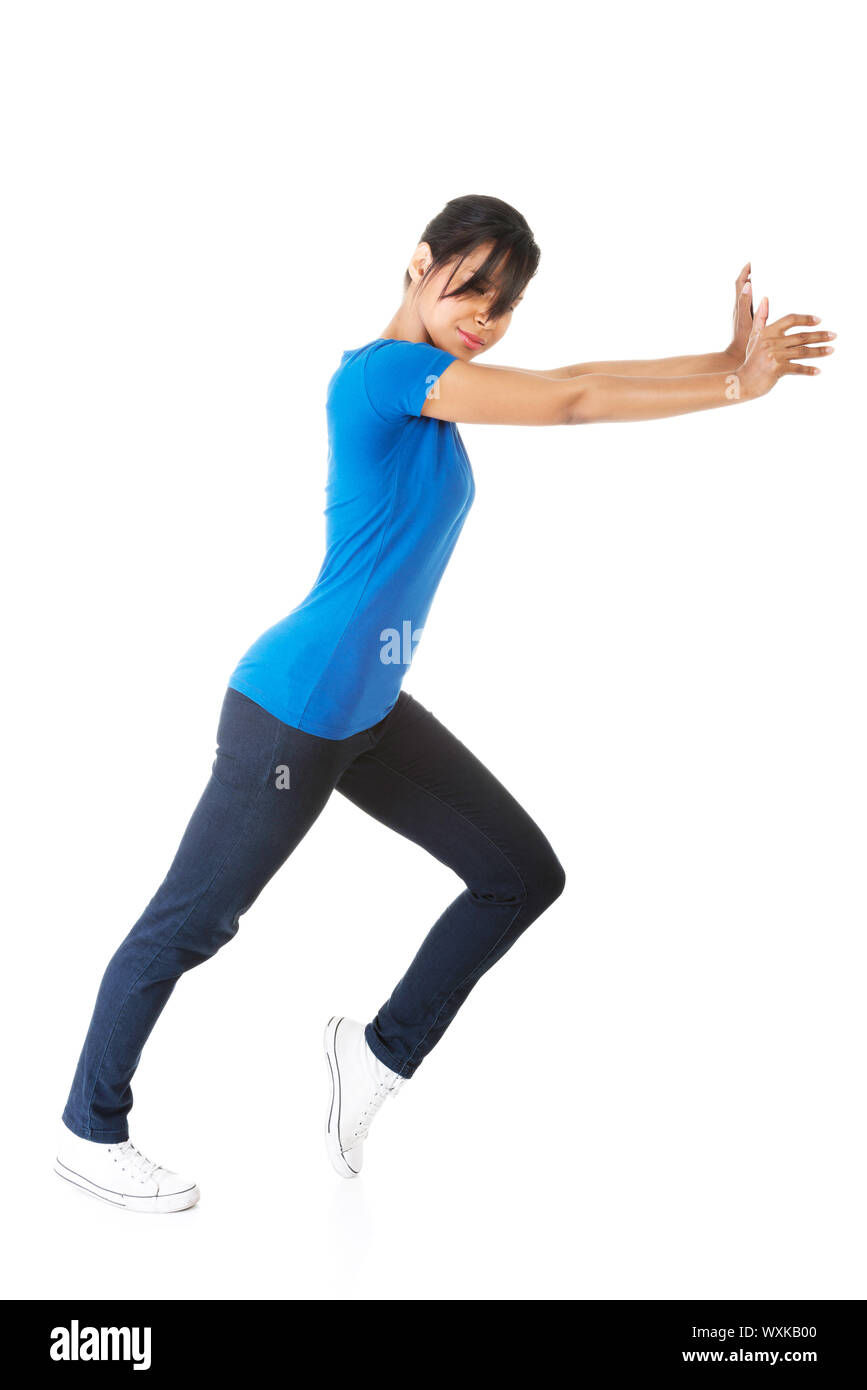 Woman pushing something imaginary isolated over a white background ...