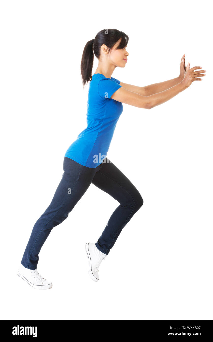 Woman pushing something imaginary isolated over a white background ...