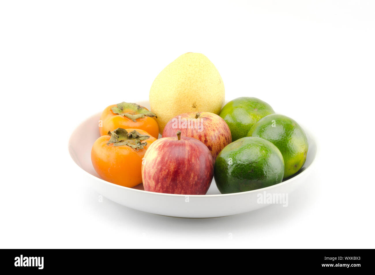 chinese pear apple green orange and persimon on white dish isolated on ...