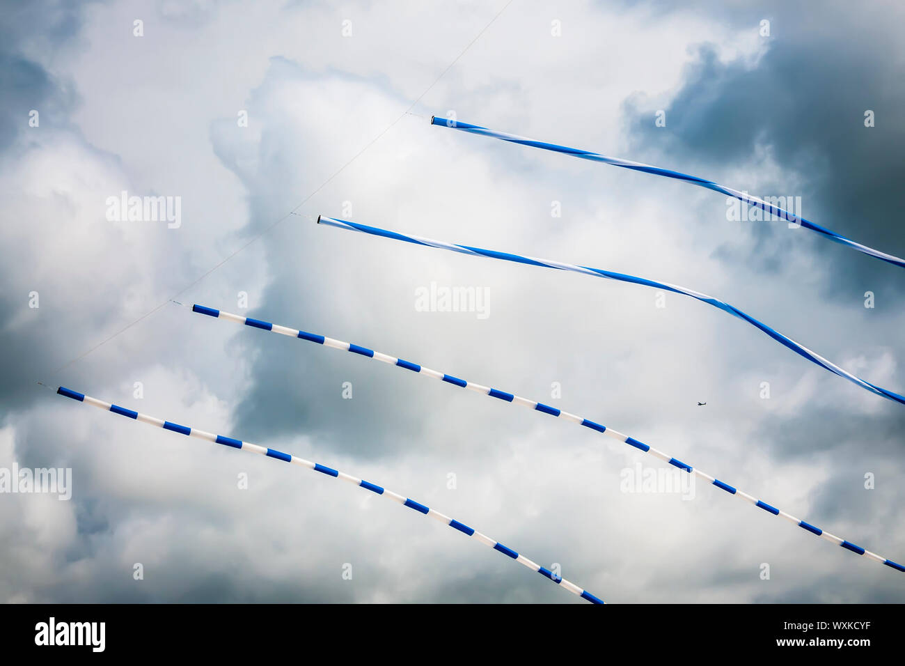 Picture of long blue white flying kites with dark clouds on sky Stock ...