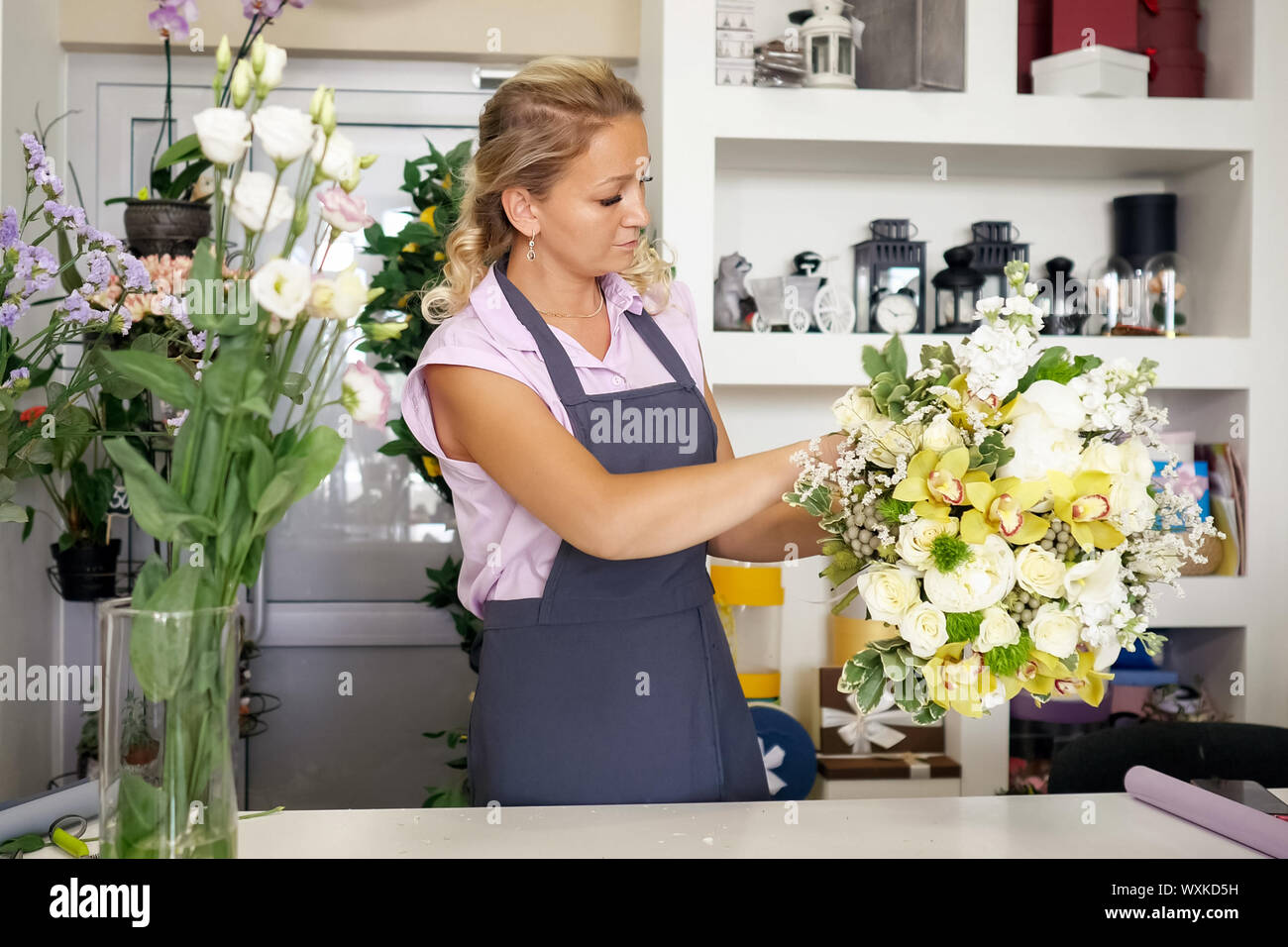 Working in flower shop. Professional florist is creating huge beautiful ...