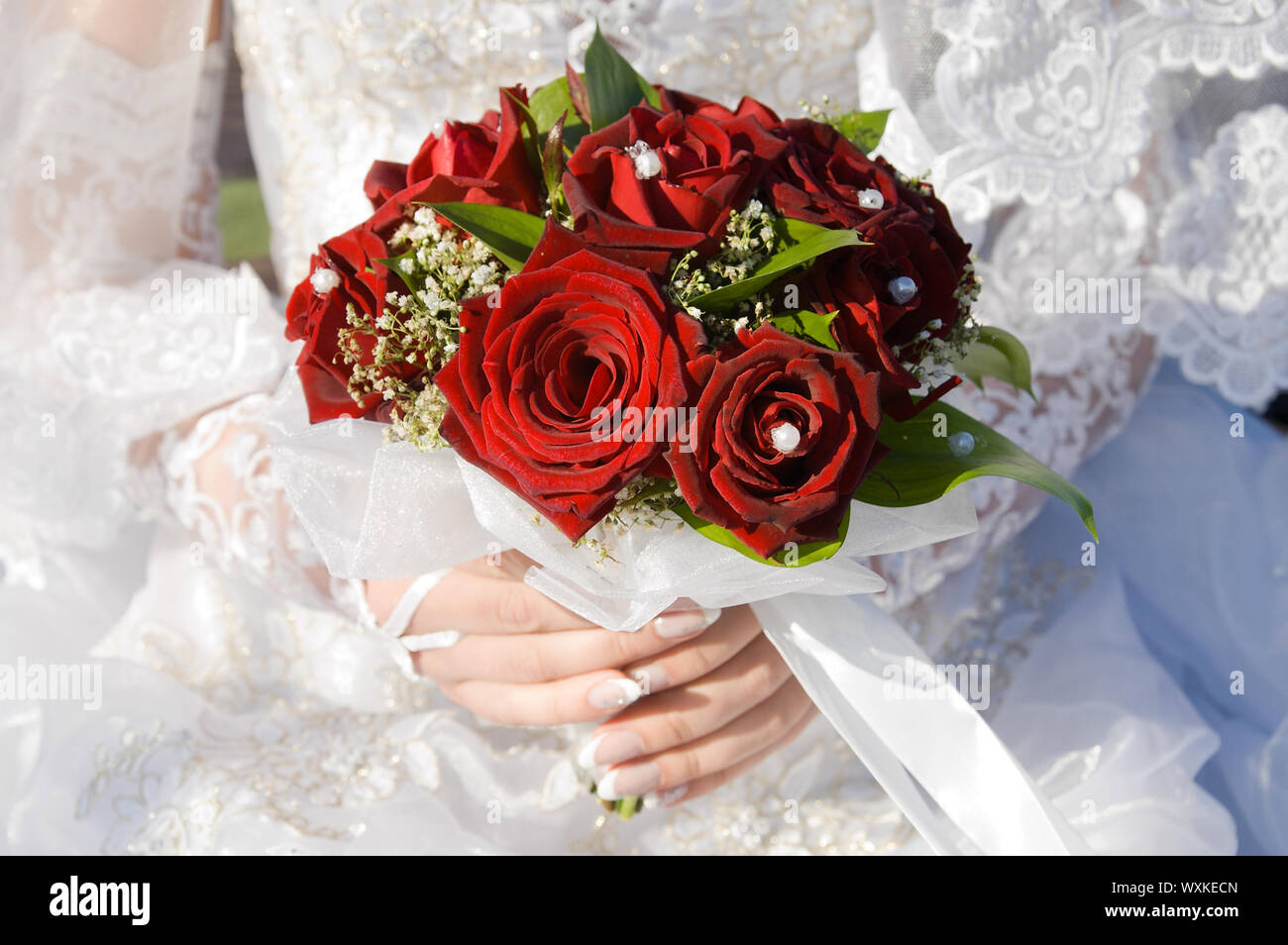 red roses bouquet in married woman's hand Stock Photo - Alamy