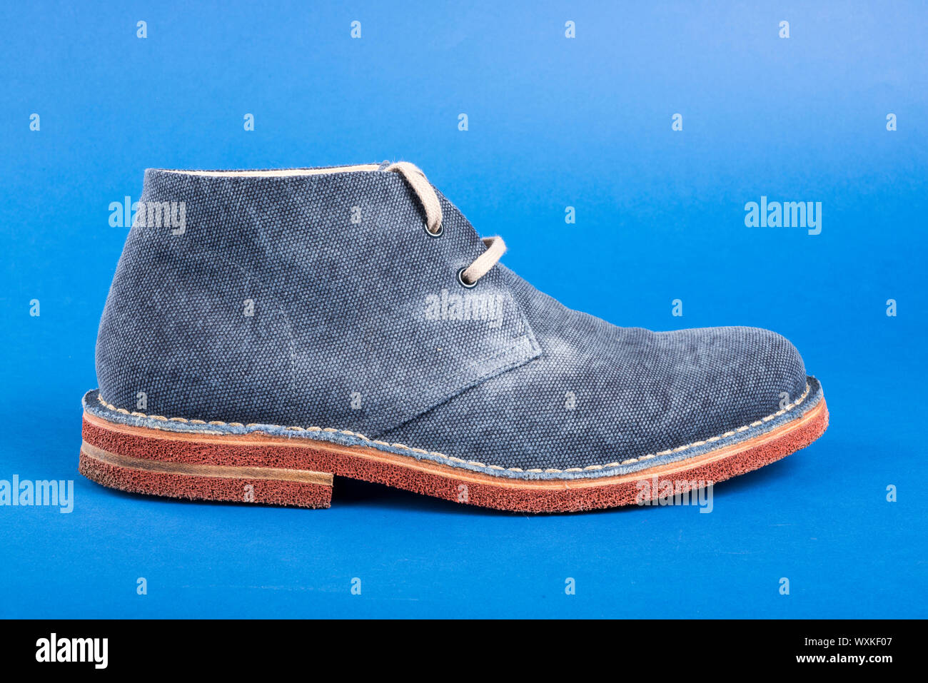 Men's denim shoe on a blue background Stock Photo - Alamy