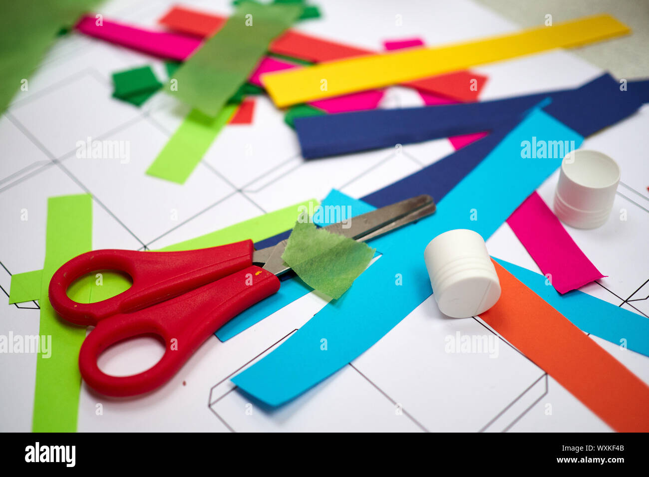 A childrens craft session in front of a teacher cutting up colourful ...