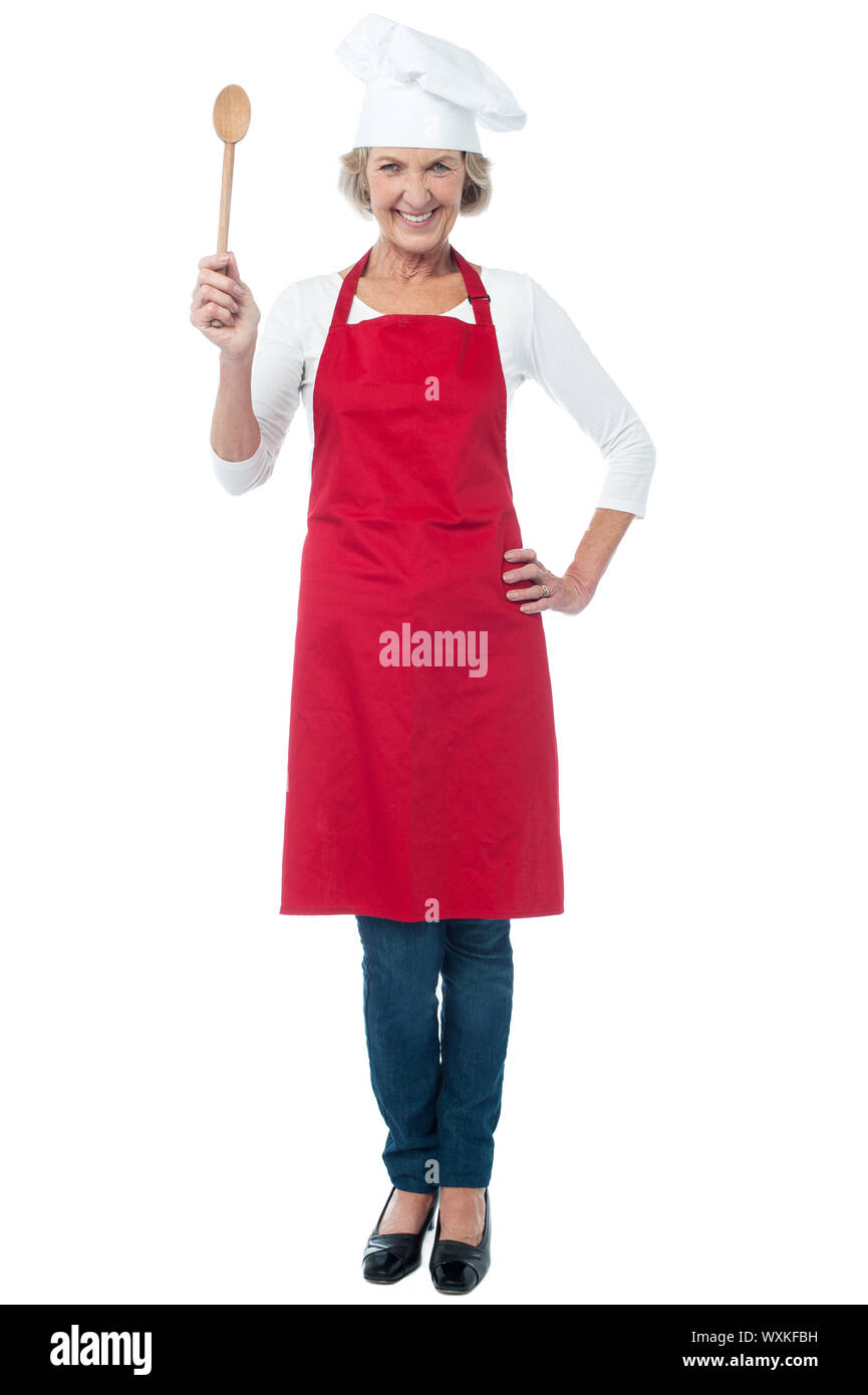 Joyous smiling aged female chef holding spoon Stock Photo - Alamy