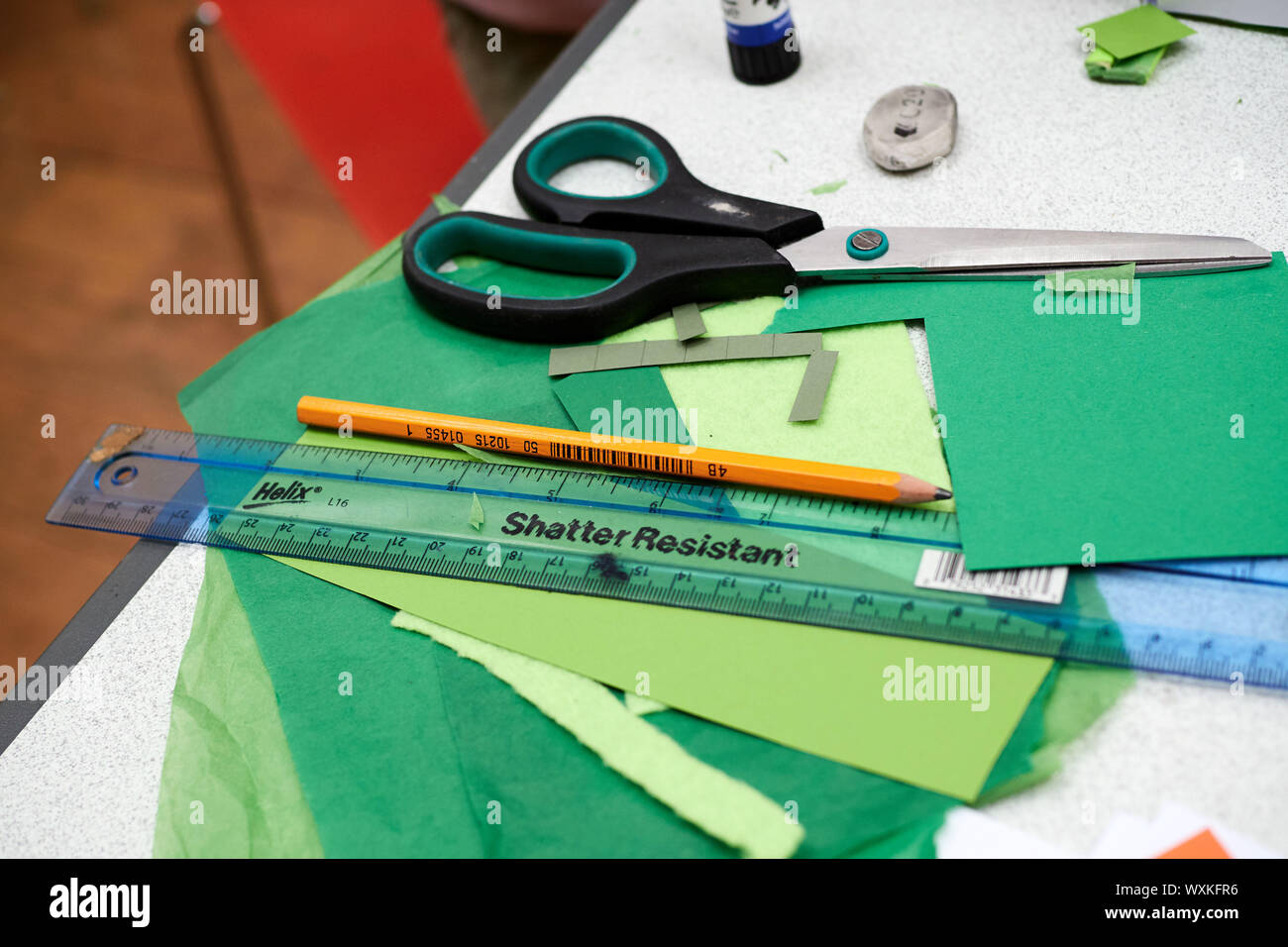 A childrens craft session in front of a teacher cutting up colourful ...
