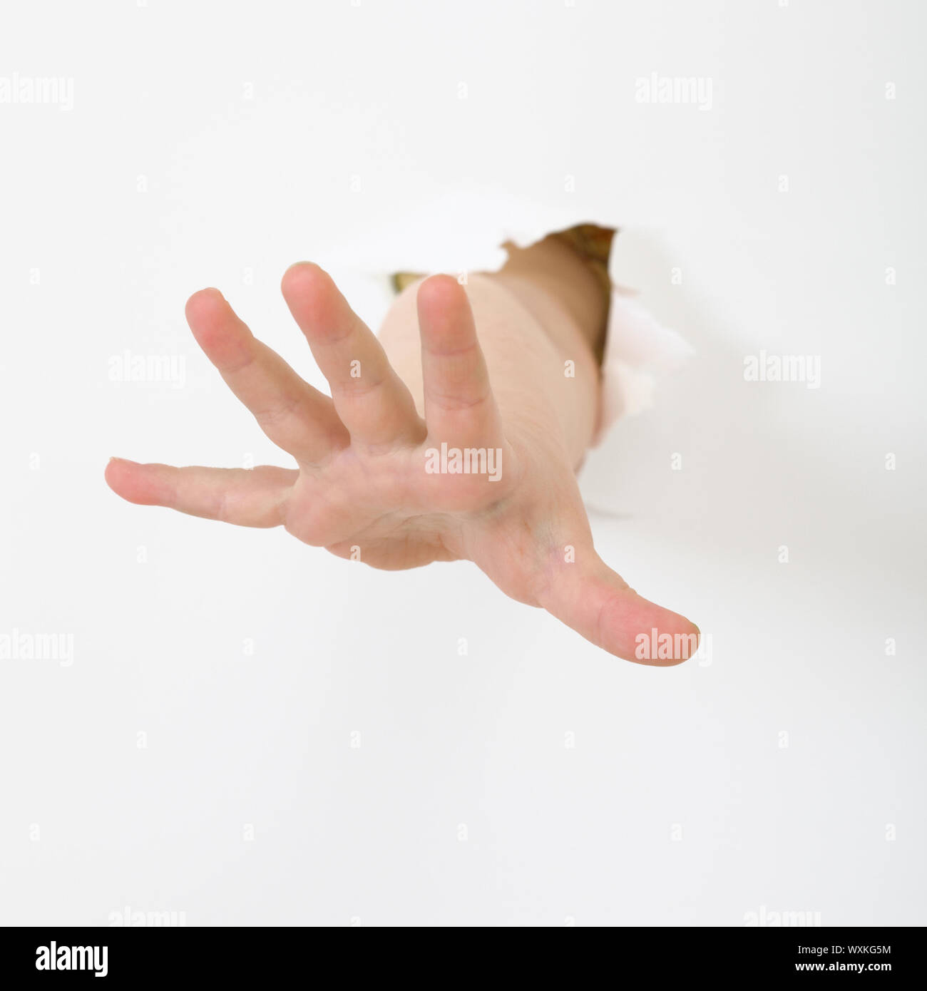 Child's hand stick out from hole in sheet of paper Stock Photo - Alamy