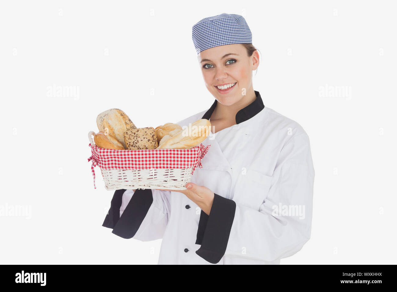 Portrait of young woman in chef uniform with bread basket against white ...