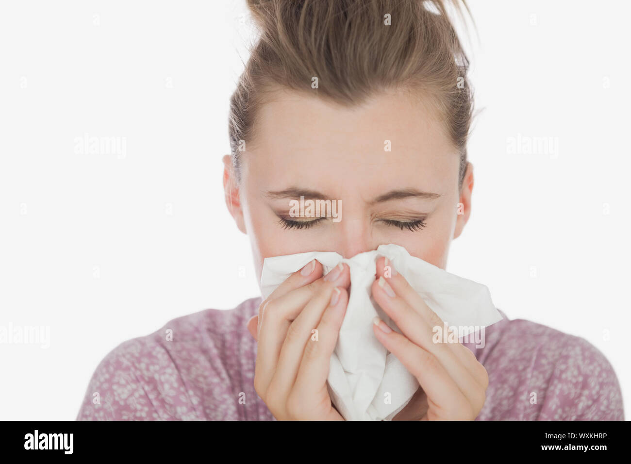 Closeup of young woman suffering from cold against white background ...