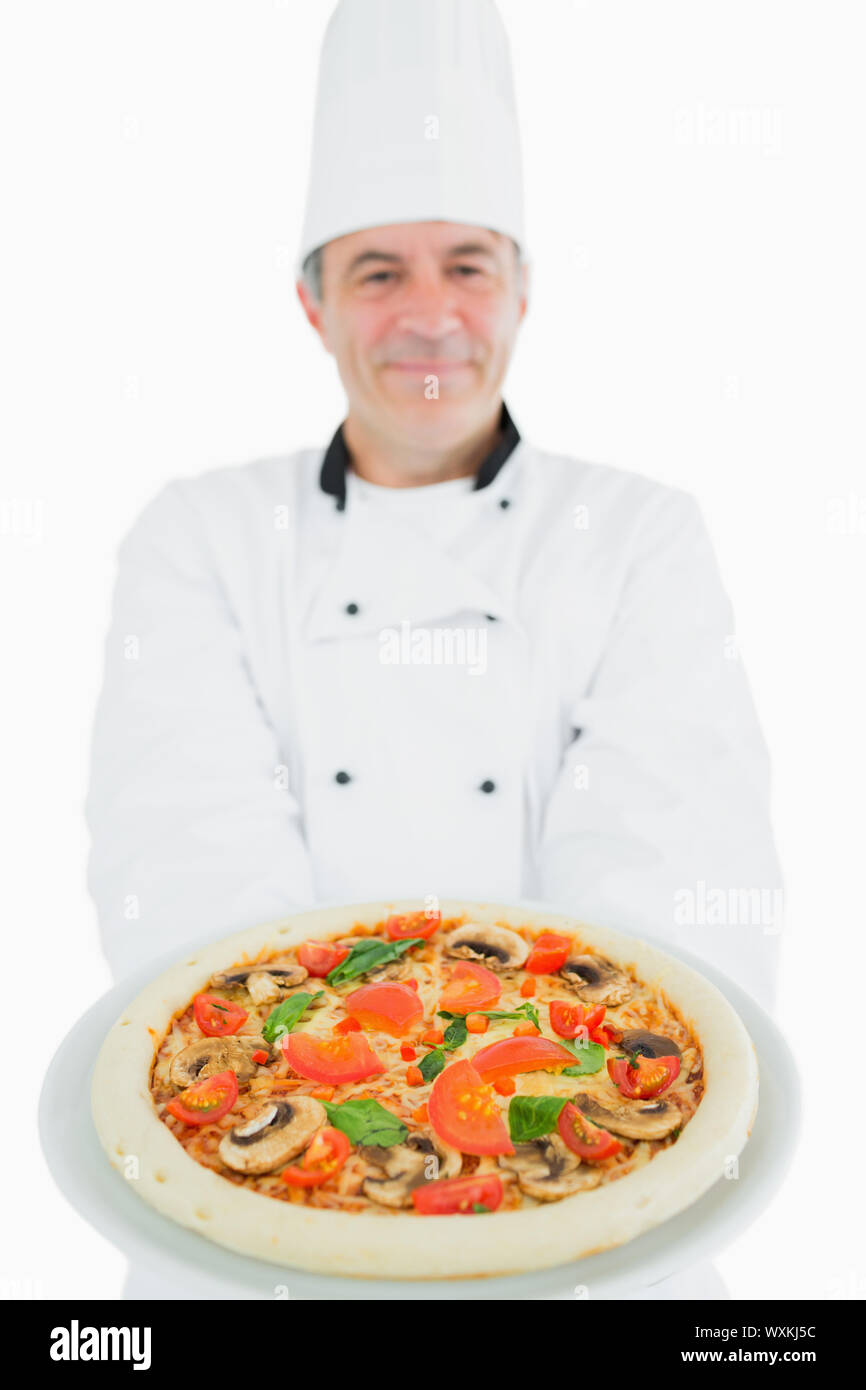 Portrait of male chef holding delicious pizza over white background ...