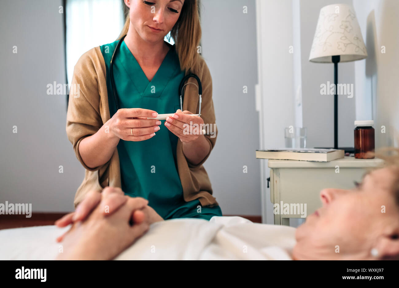 Nurse taking female patient temperature hi-res stock photography and images - Alamy