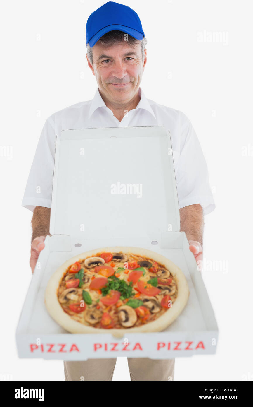 Portrait of mature delivery man holding pizza against white background ...