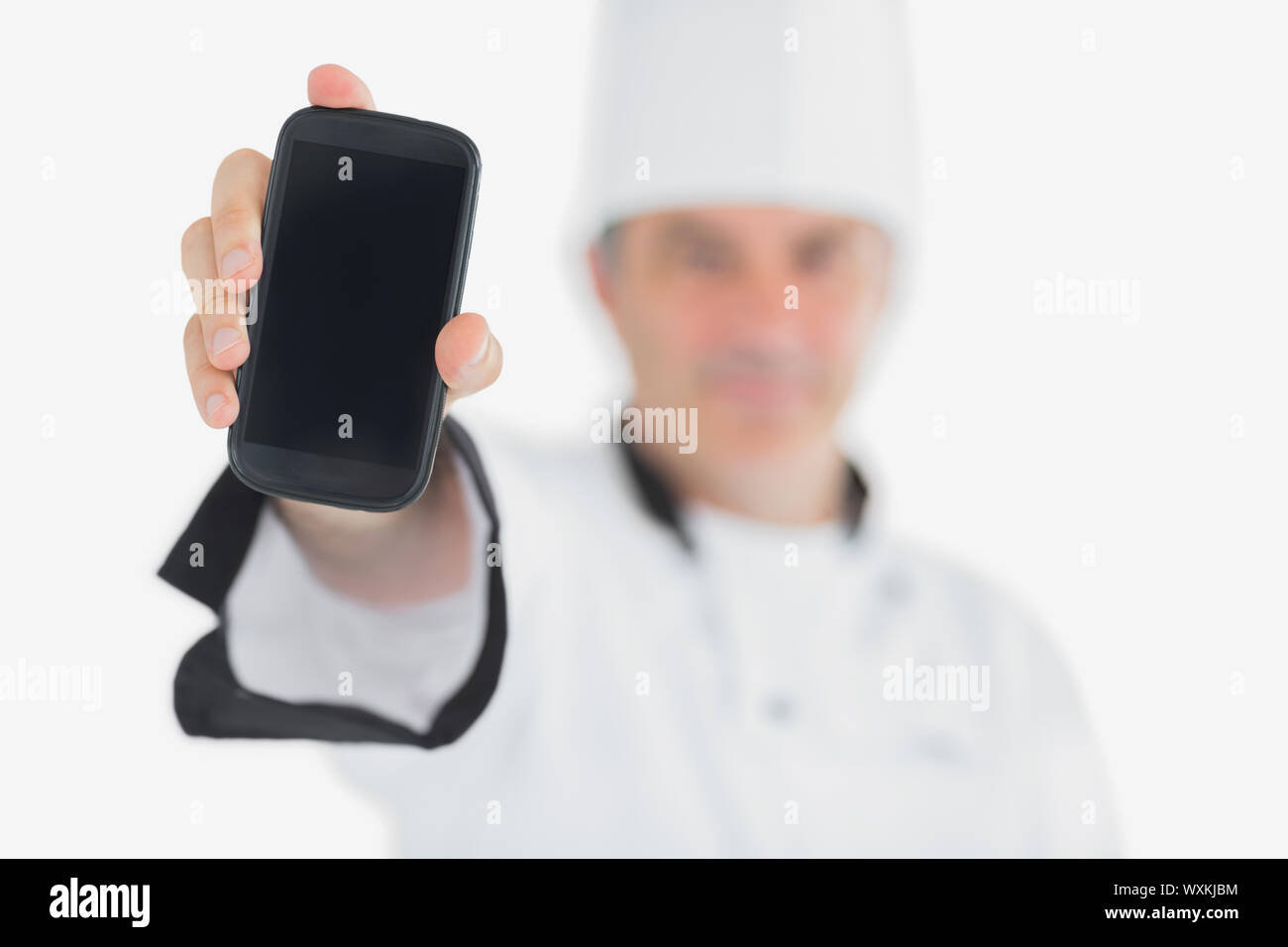 Male chef displaying smartphone against white background Stock Photo ...