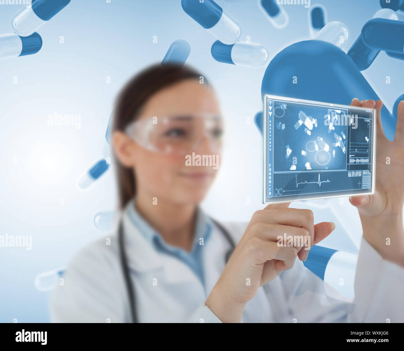 Smiling nurse holding virtual screen against pills background Stock ...
