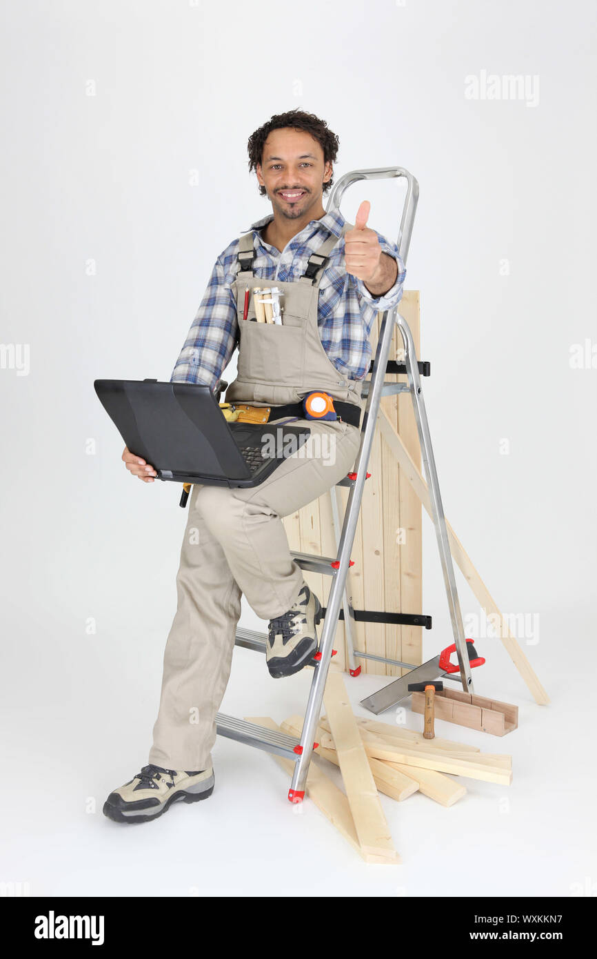 Carpenter sitting on a stepladder with a laptop computer Stock Photo ...