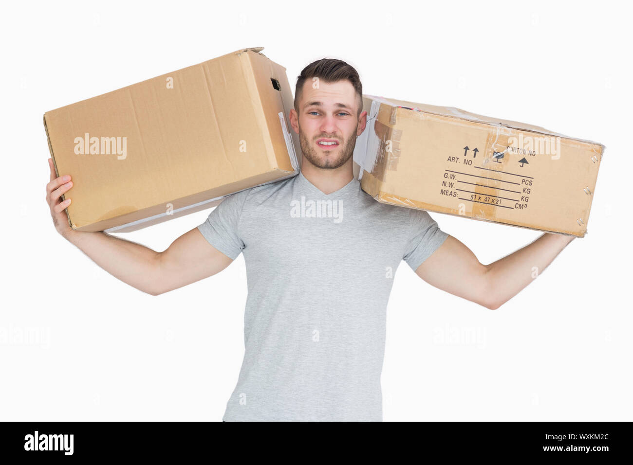 Portrait of tired young man carrying package boxes over white ...