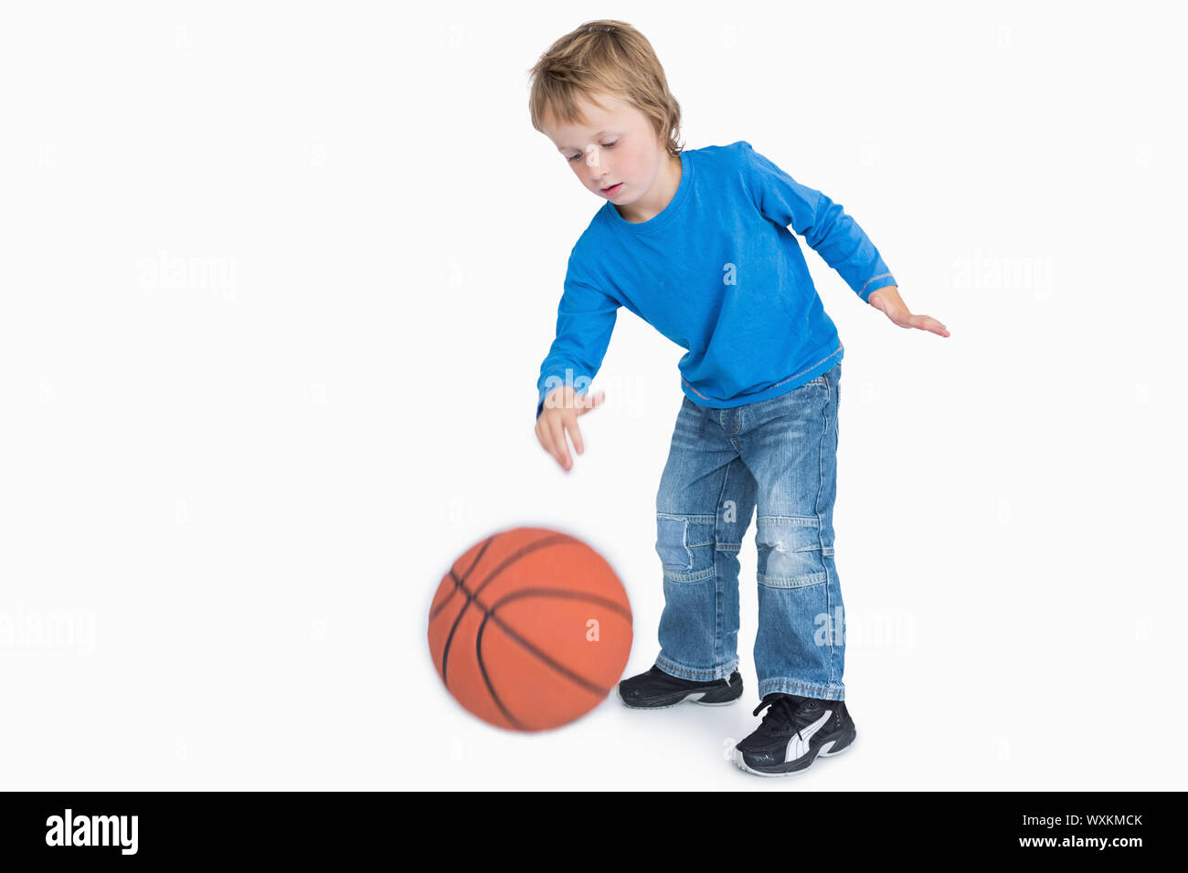 Young casual boy playing basketball over white background Stock Photo ...