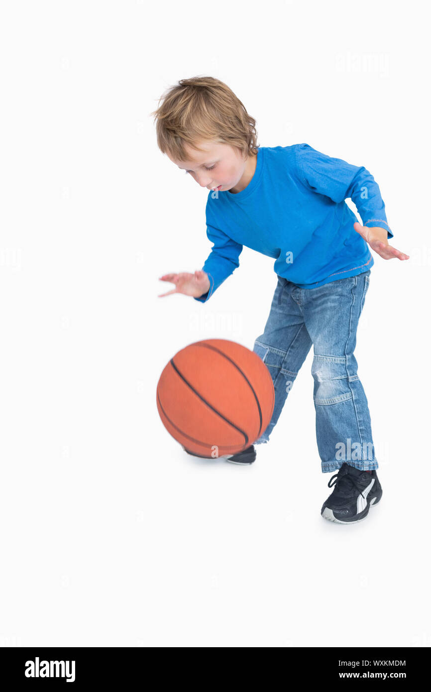 Young casual boy playing basketball over white background Stock Photo ...