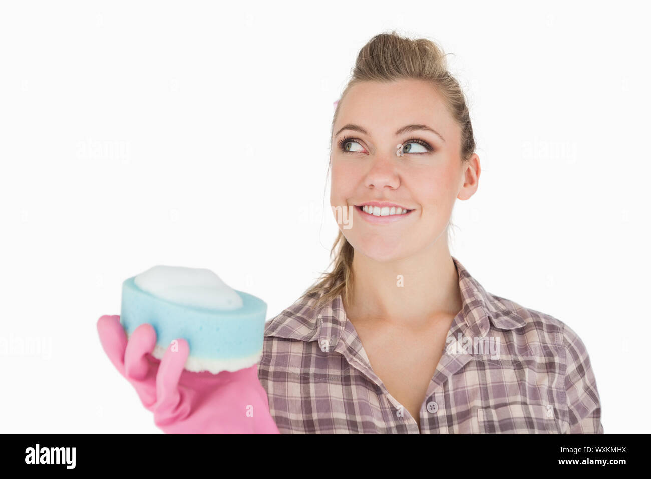 Smiling woman holding soap suds over sponge against white background ...