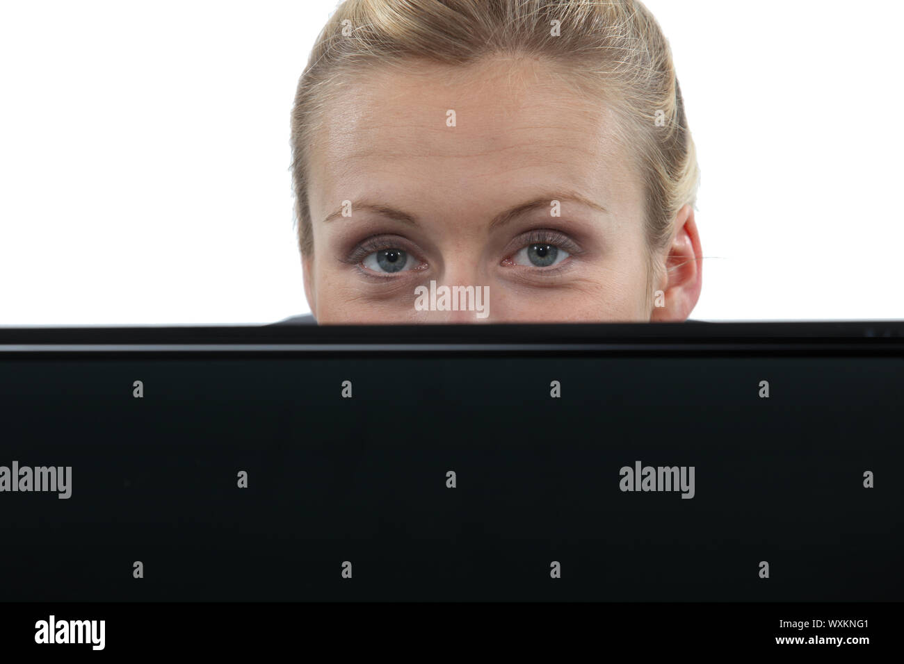 Woman hiding behind laptop computer Stock Photo - Alamy