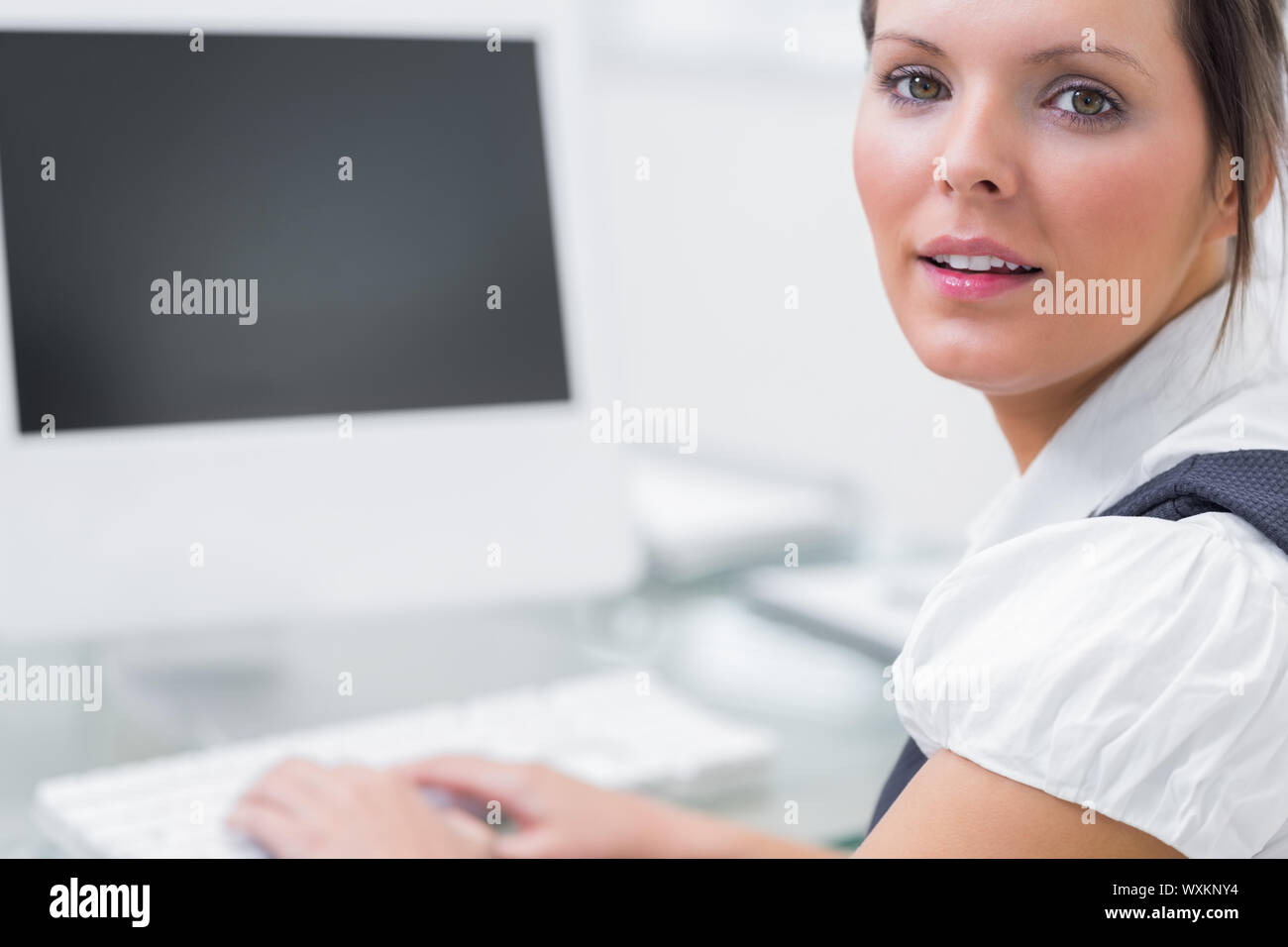 Closeup portrait of confident female executive using computer at office ...