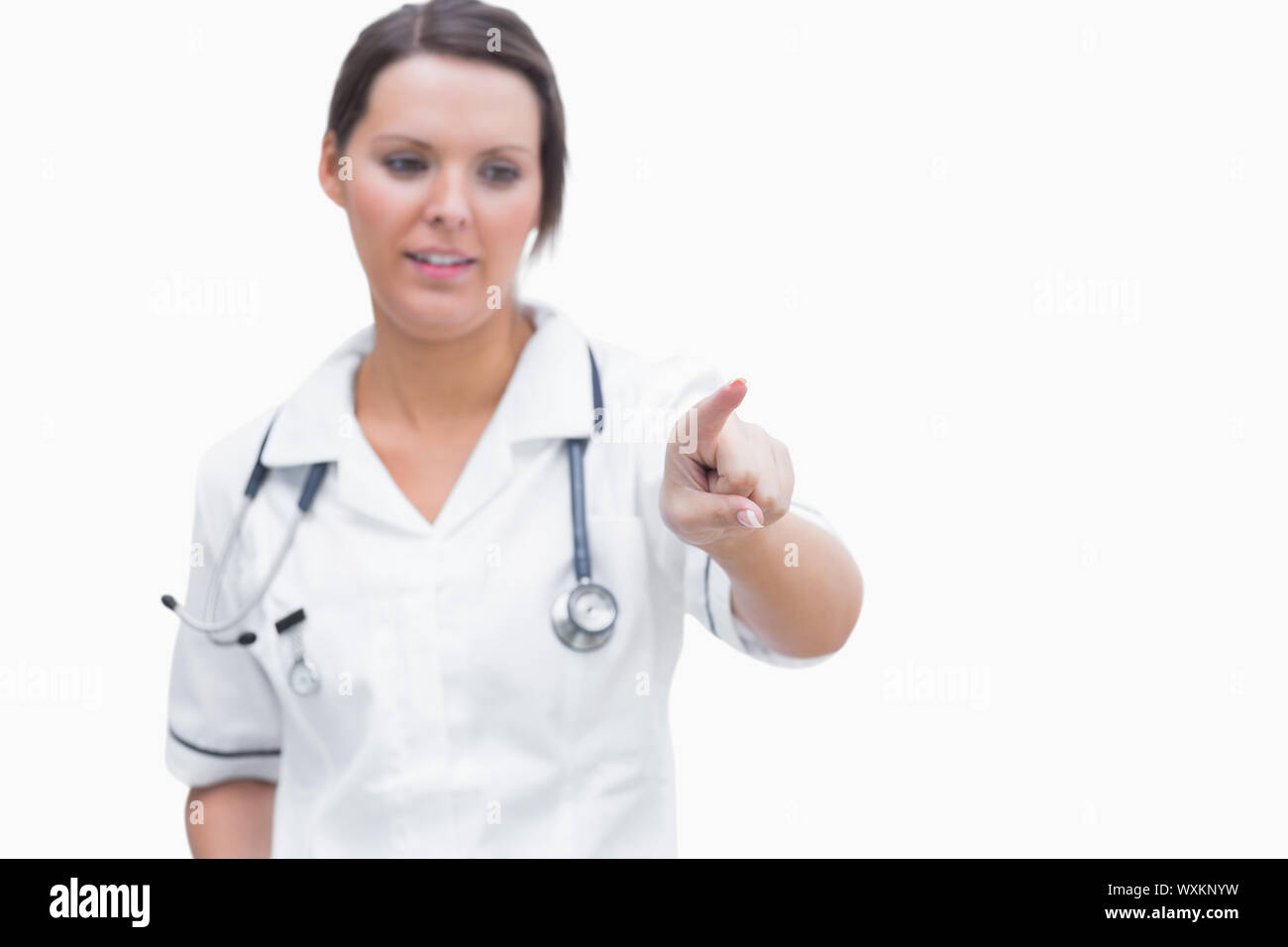 Female nurse pointing at invisible screen against white background ...