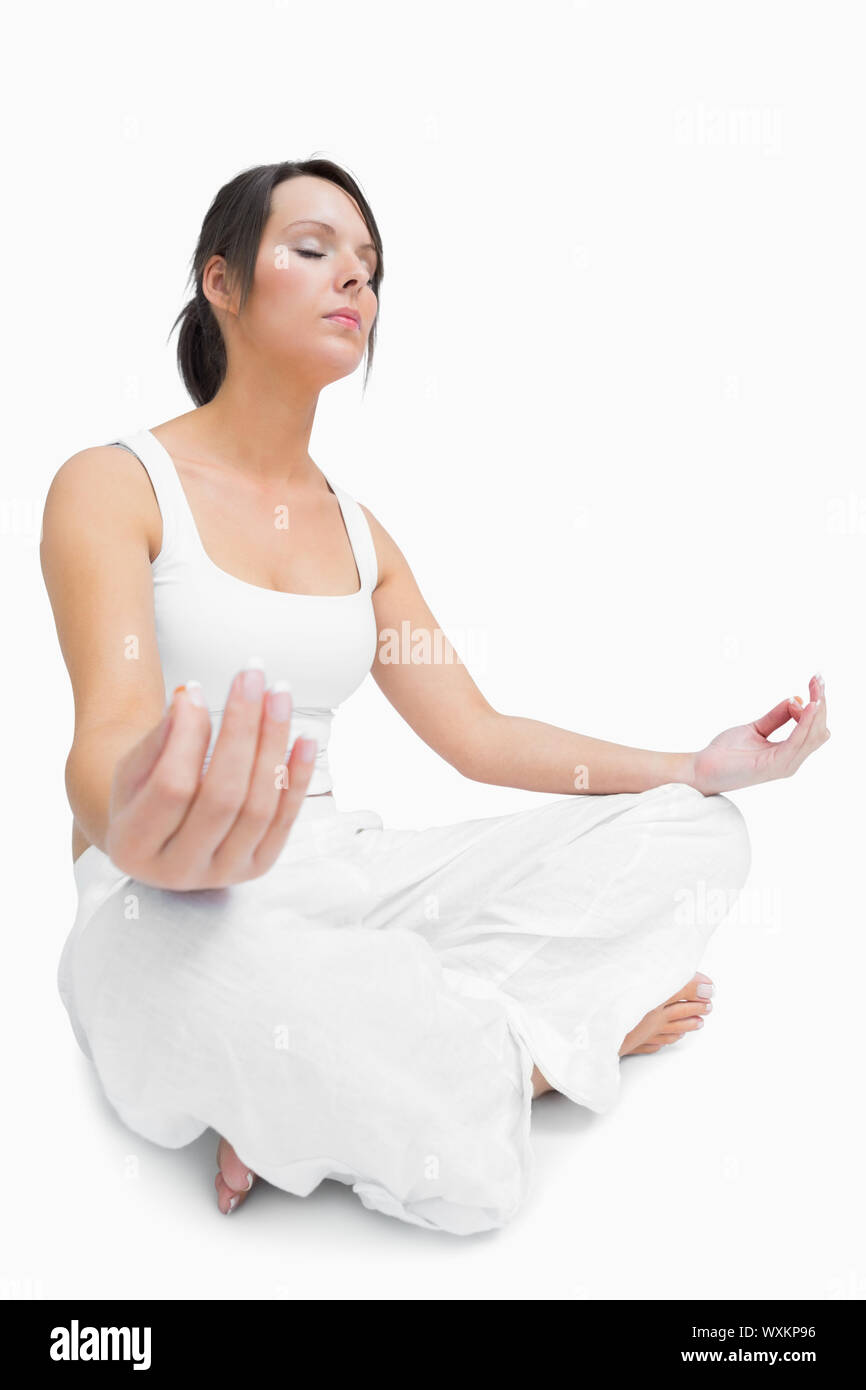 Young woman sitting in lotus position over white background Stock Photo ...