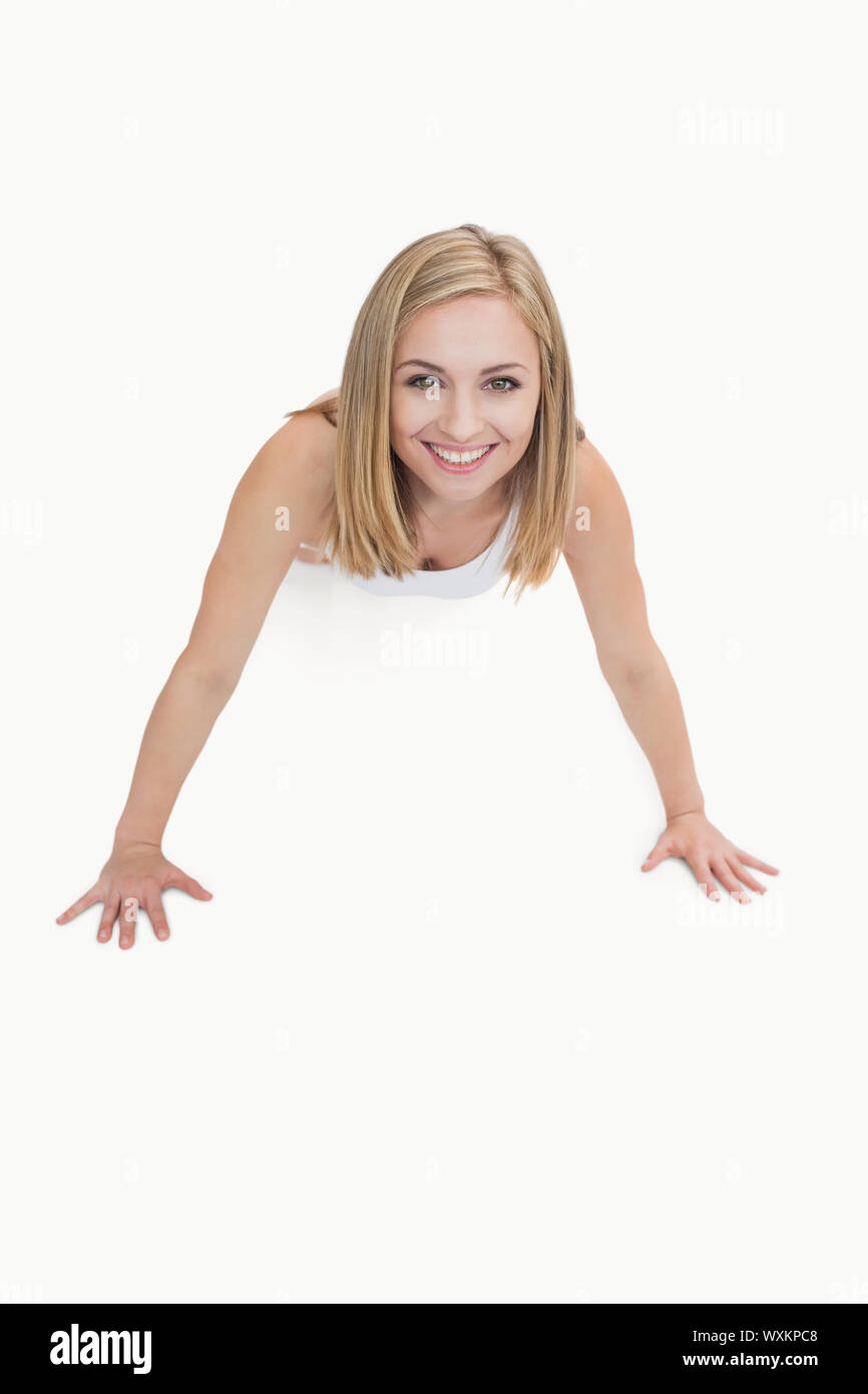 Portrait of happy young woman doing pushups over white background Stock ...