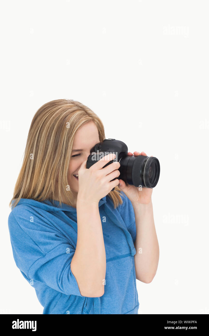 Side view of female photographer with photographic camera over white ...