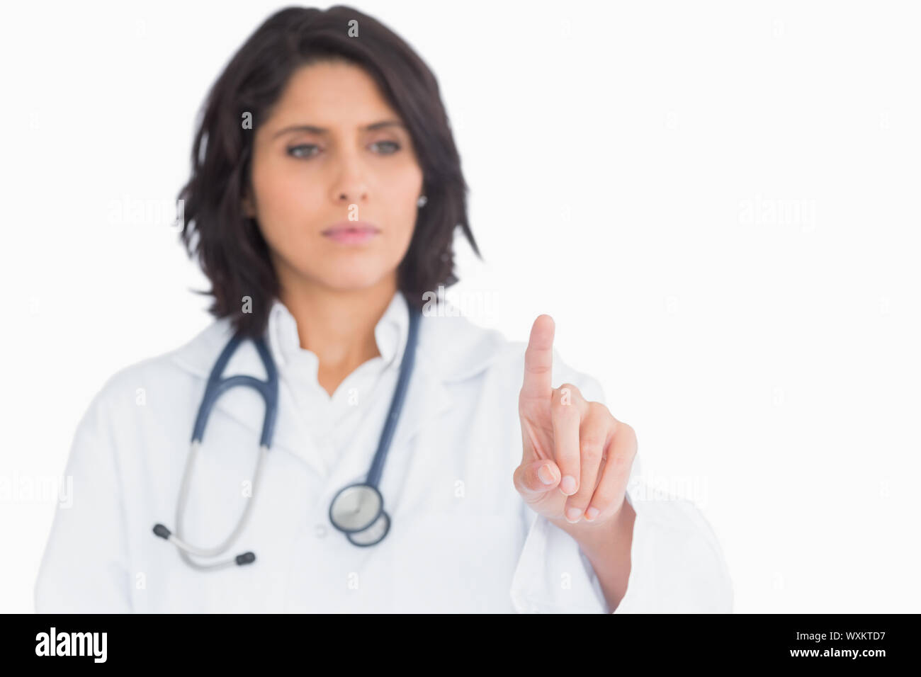 Pretty doctor pointing the finger in the air on white background Stock ...