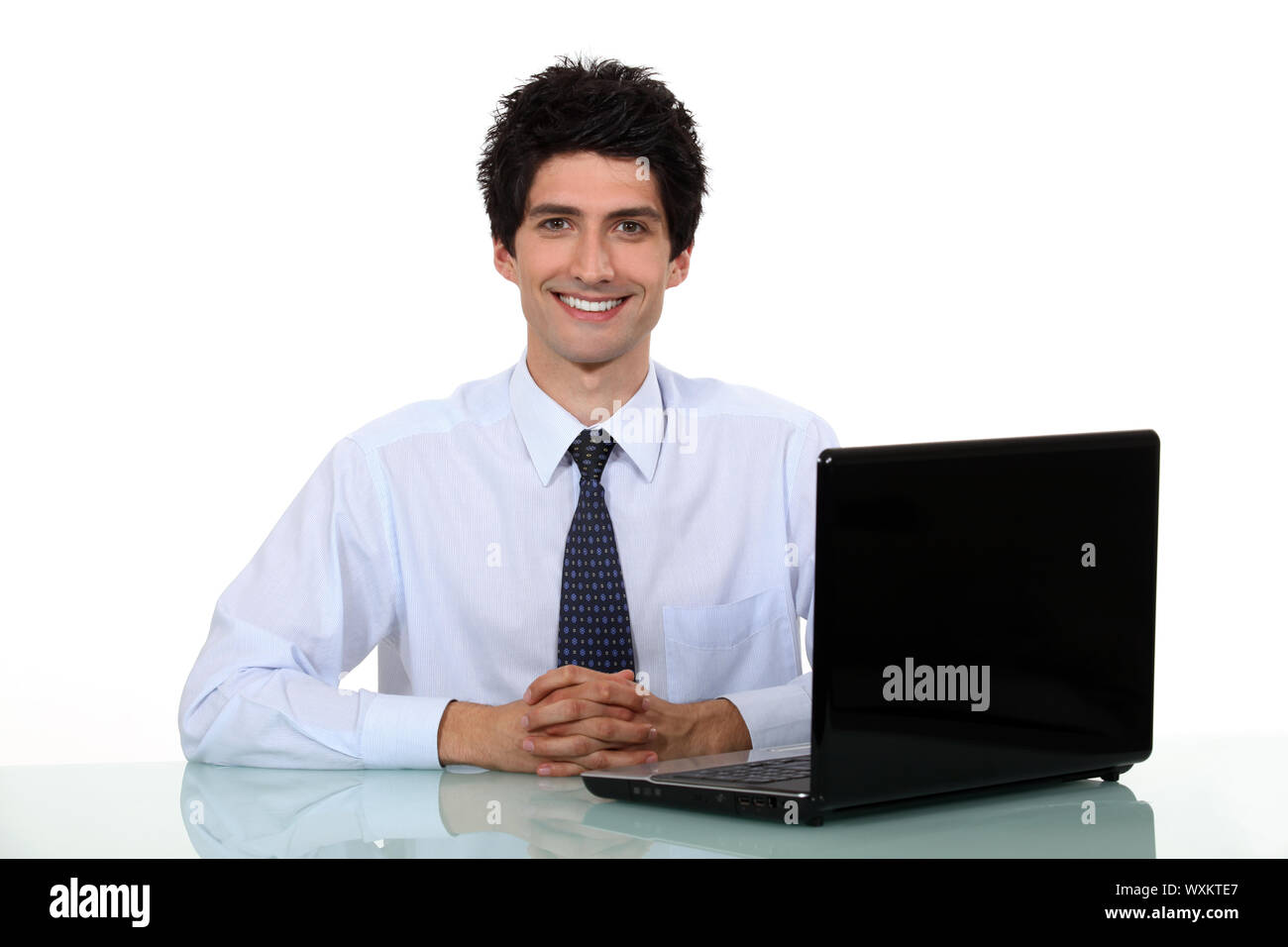 Happy office worker sat at his desk smiling Stock Photo - Alamy