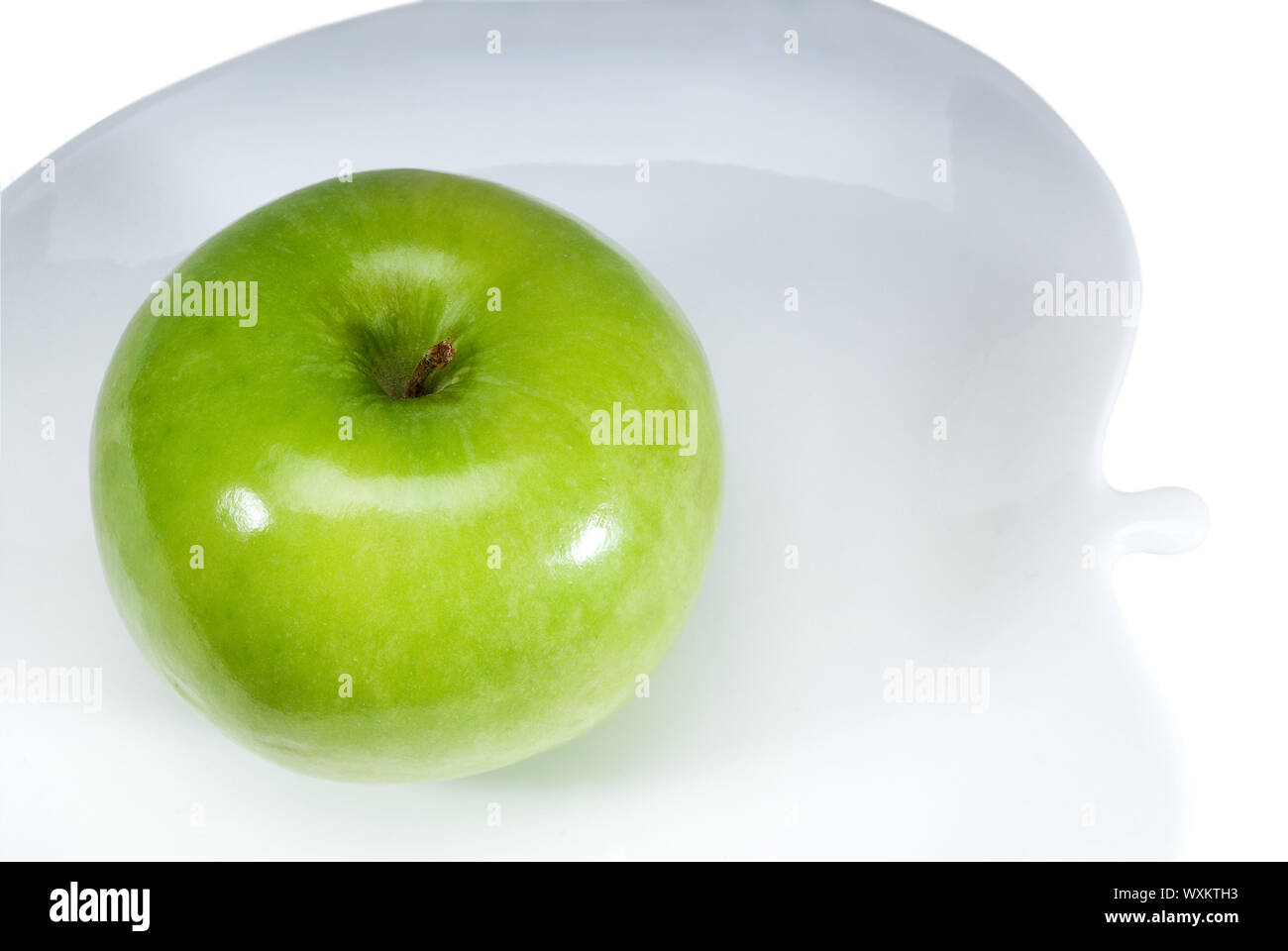 green apple on a apple shaped dish isolated over white Stock Photo - Alamy