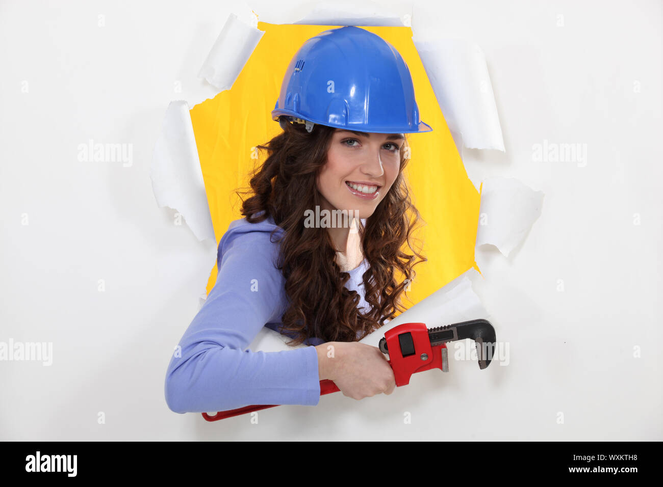 Female manual worker holding wrench Stock Photo - Alamy