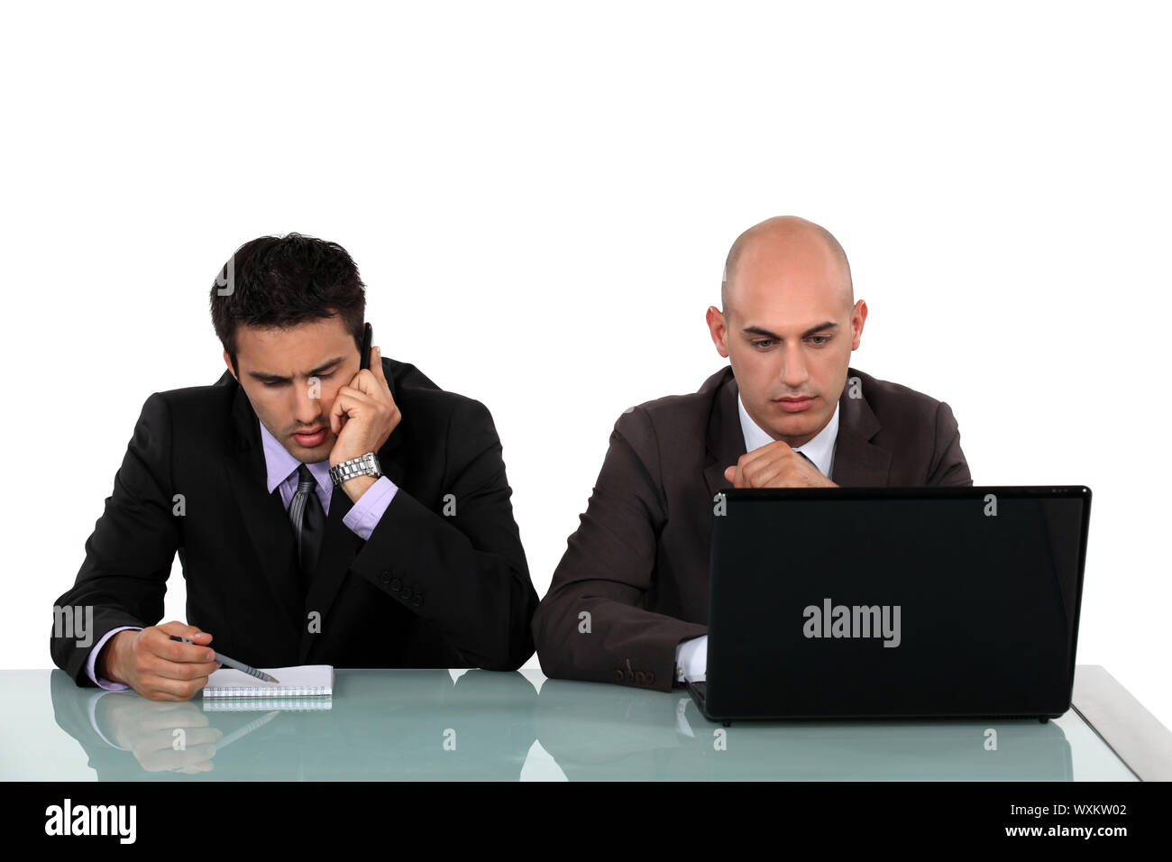 Serious businessmen working at a desk Stock Photo - Alamy