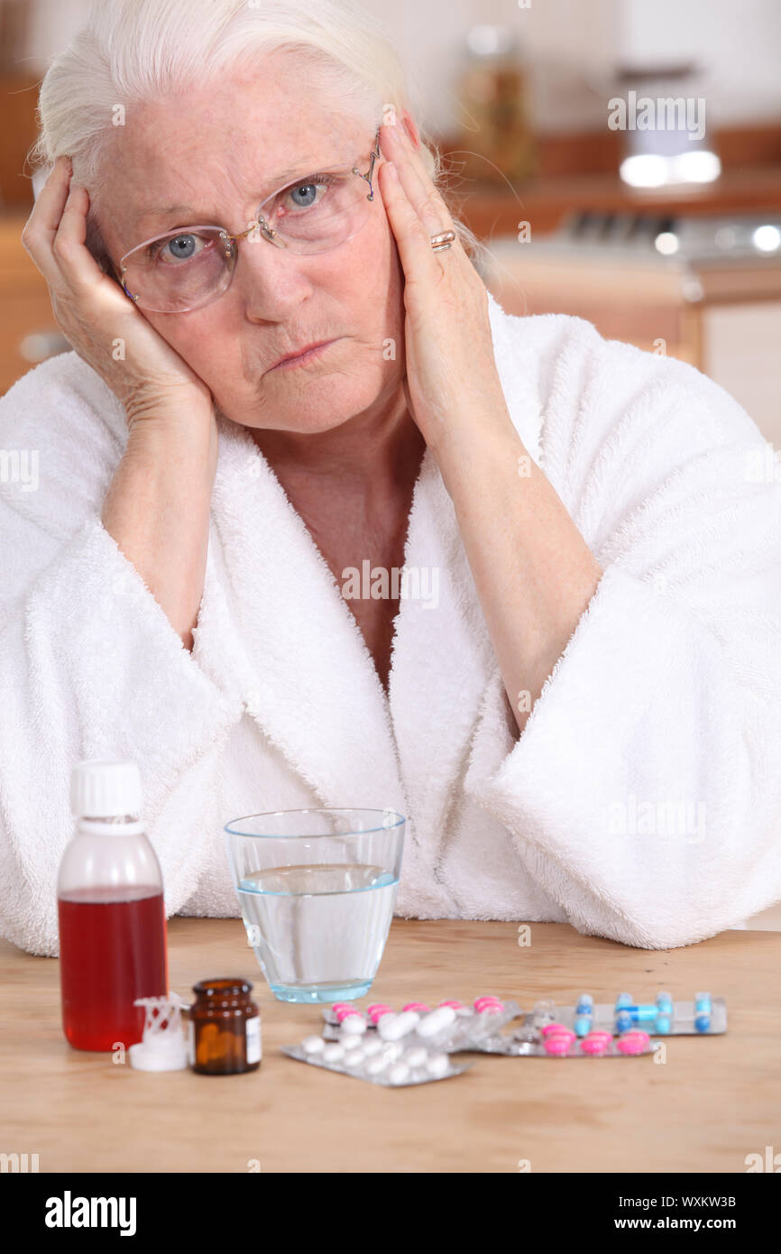 Grumpy woman taking her medication Stock Photo - Alamy