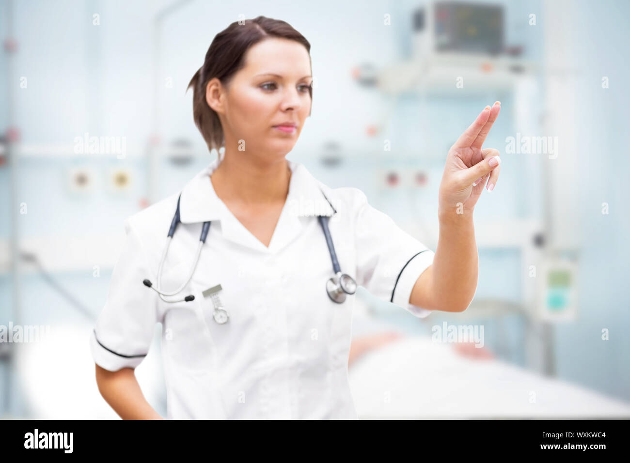 Nurse pointing at invisible screen in hospital ward Stock Photo - Alamy