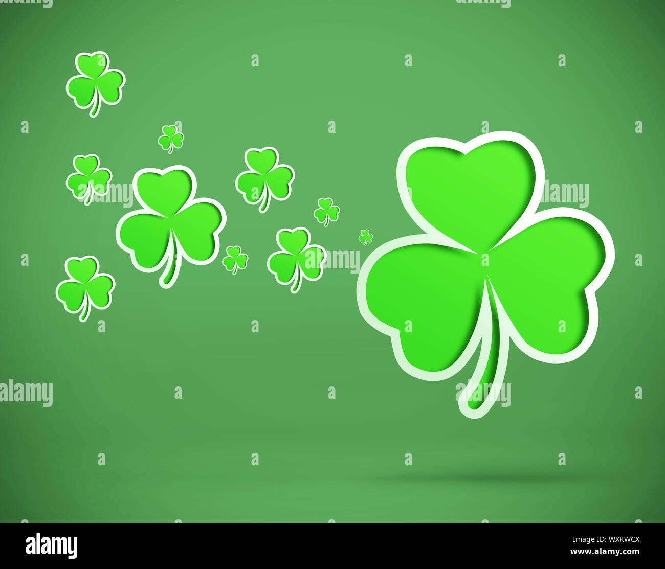 Different sized green shamrocks on green background Stock Photo - Alamy