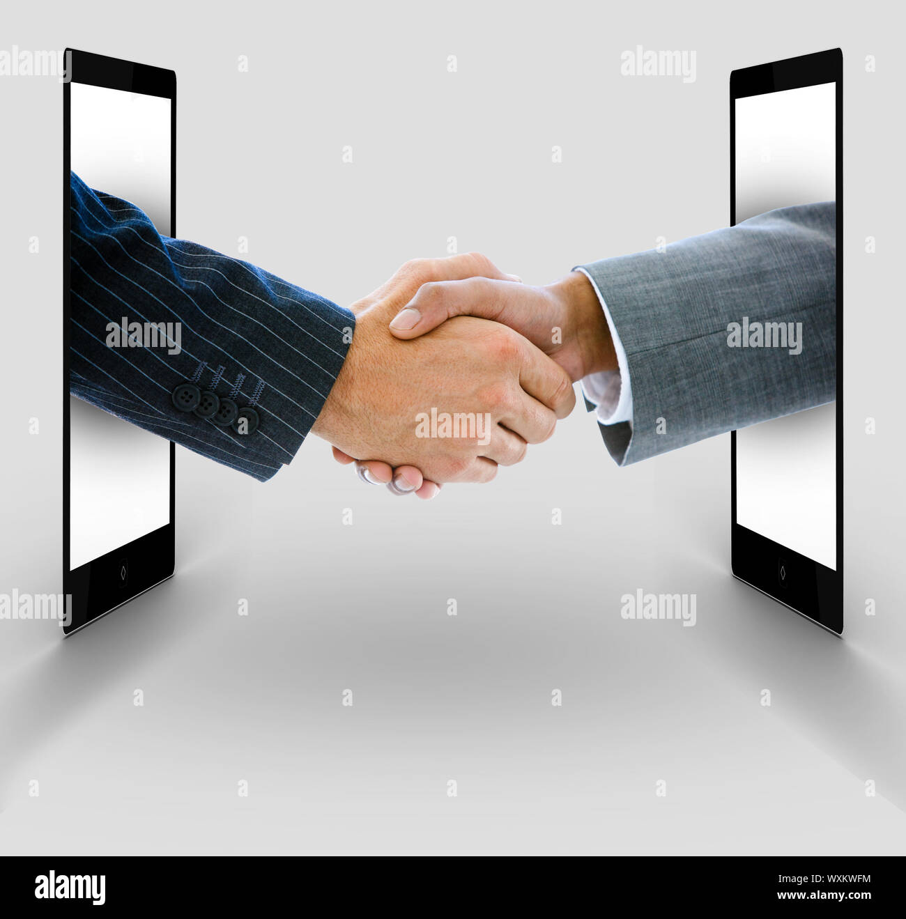 Businessmen shaking hands from digital tablets on white background ...