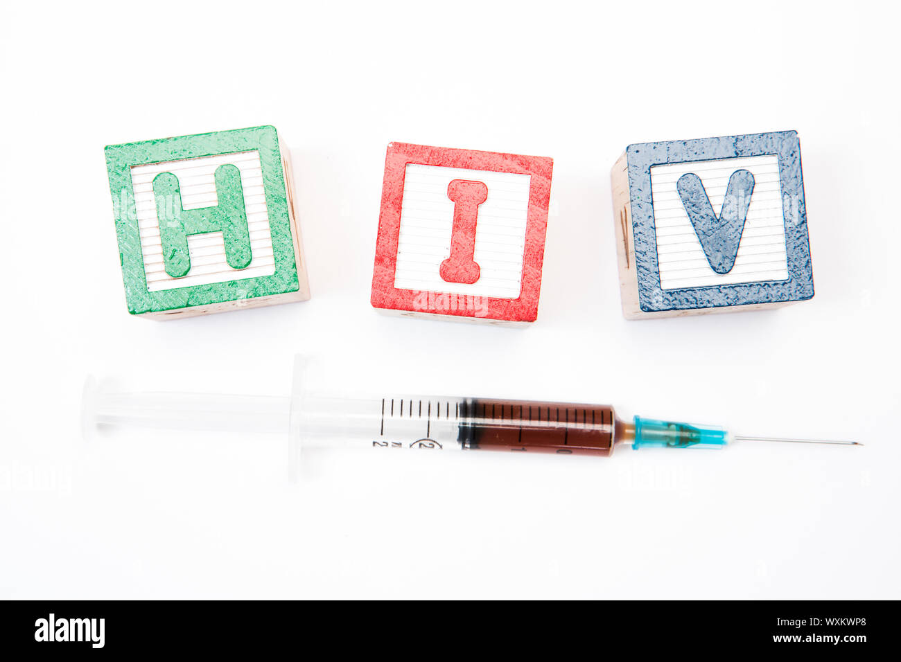 Wood blocks in green and red spelling out hiv with syringe on white ...