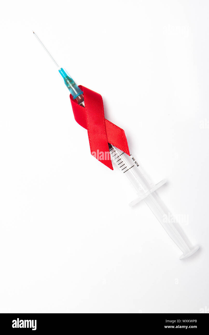 Red ribbon wrapped around syringe on white background Stock Photo - Alamy