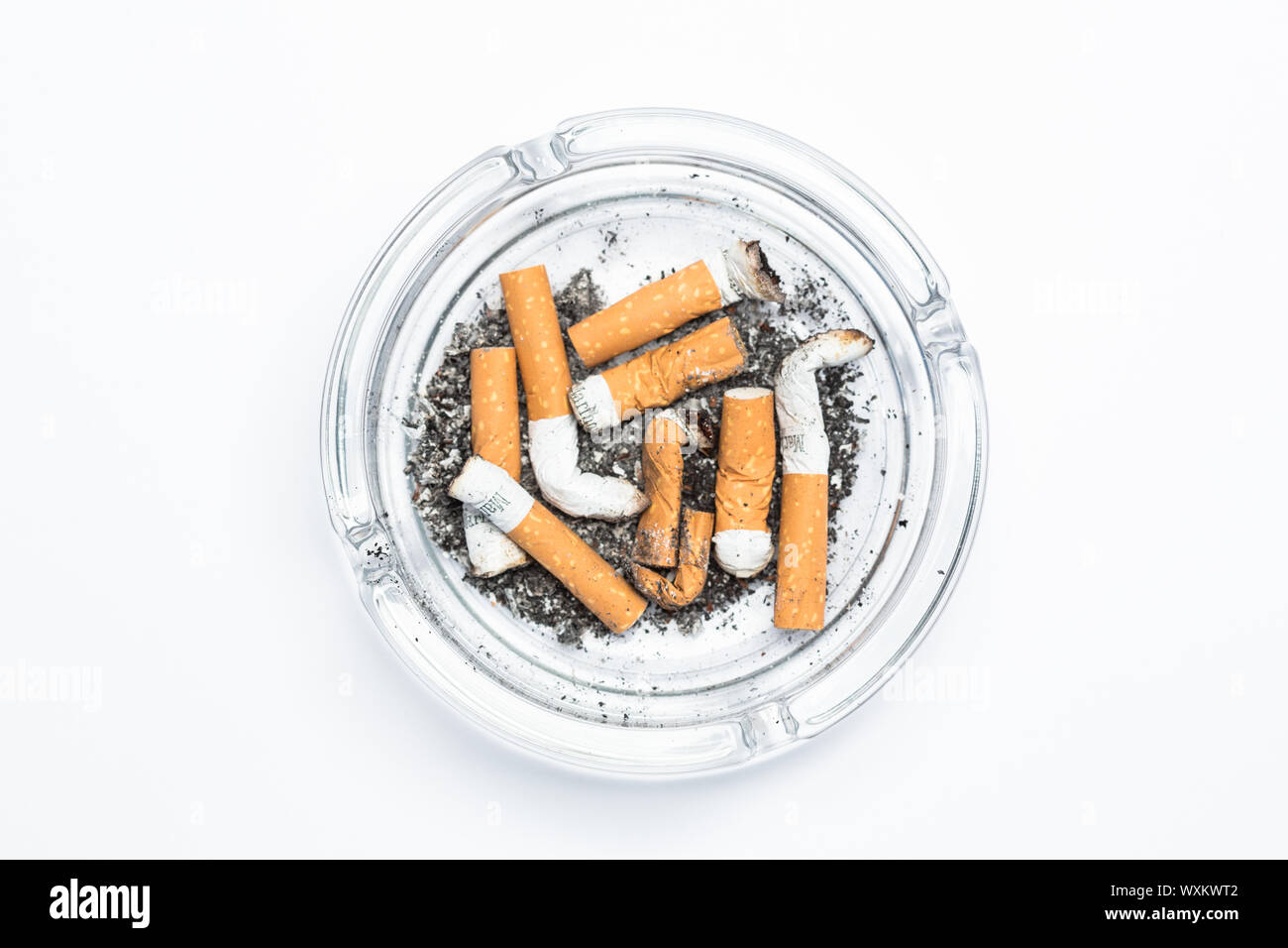 Overhead of full ashtray on white background Stock Photo - Alamy