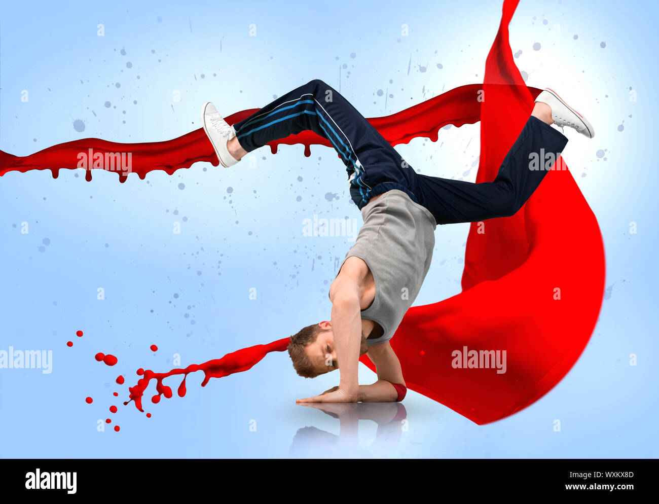 Break dancer balancing on his forearms with reflection below on red ...