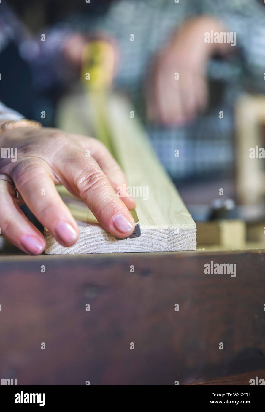 Carpenter's hand measuring in a carpentry Stock Photo - Alamy