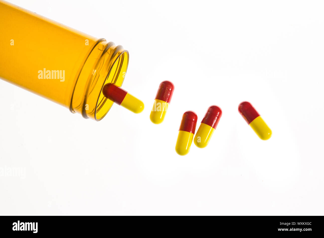 Jar of medicine spilling capsule tablets on white background Stock ...