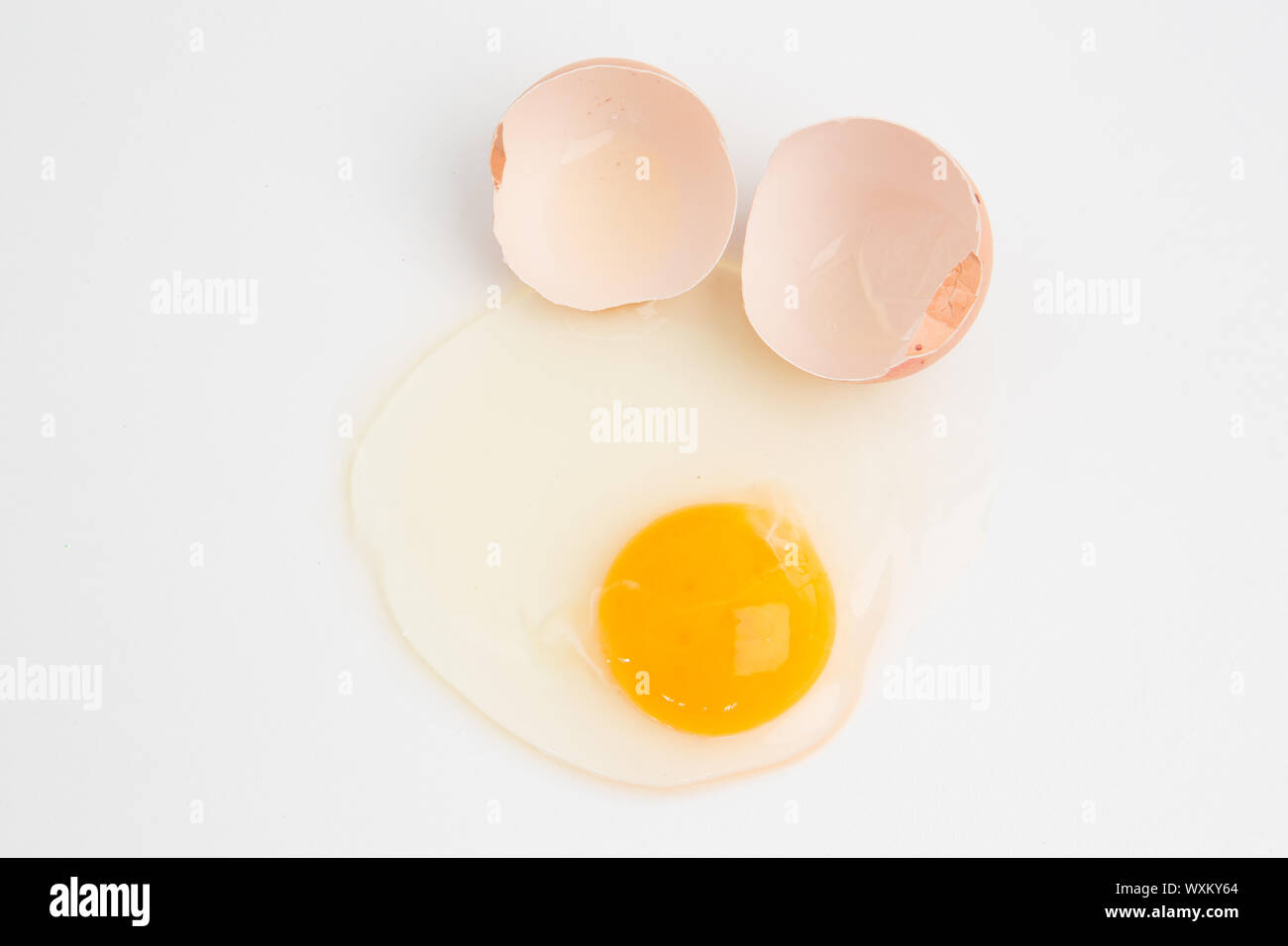 Cracked egg on white background Stock Photo - Alamy