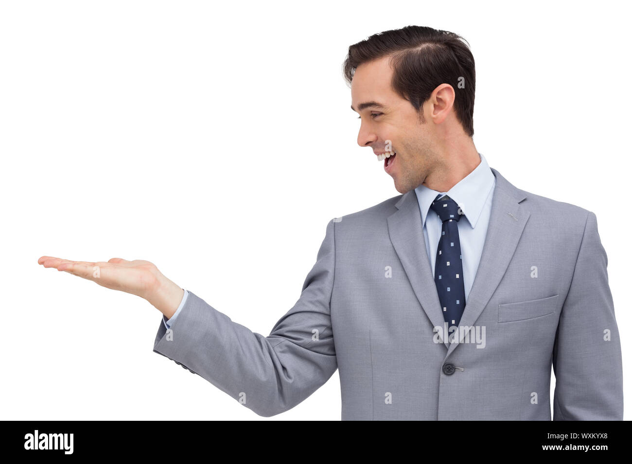 Young businessman looking at his hand against white background Stock ...