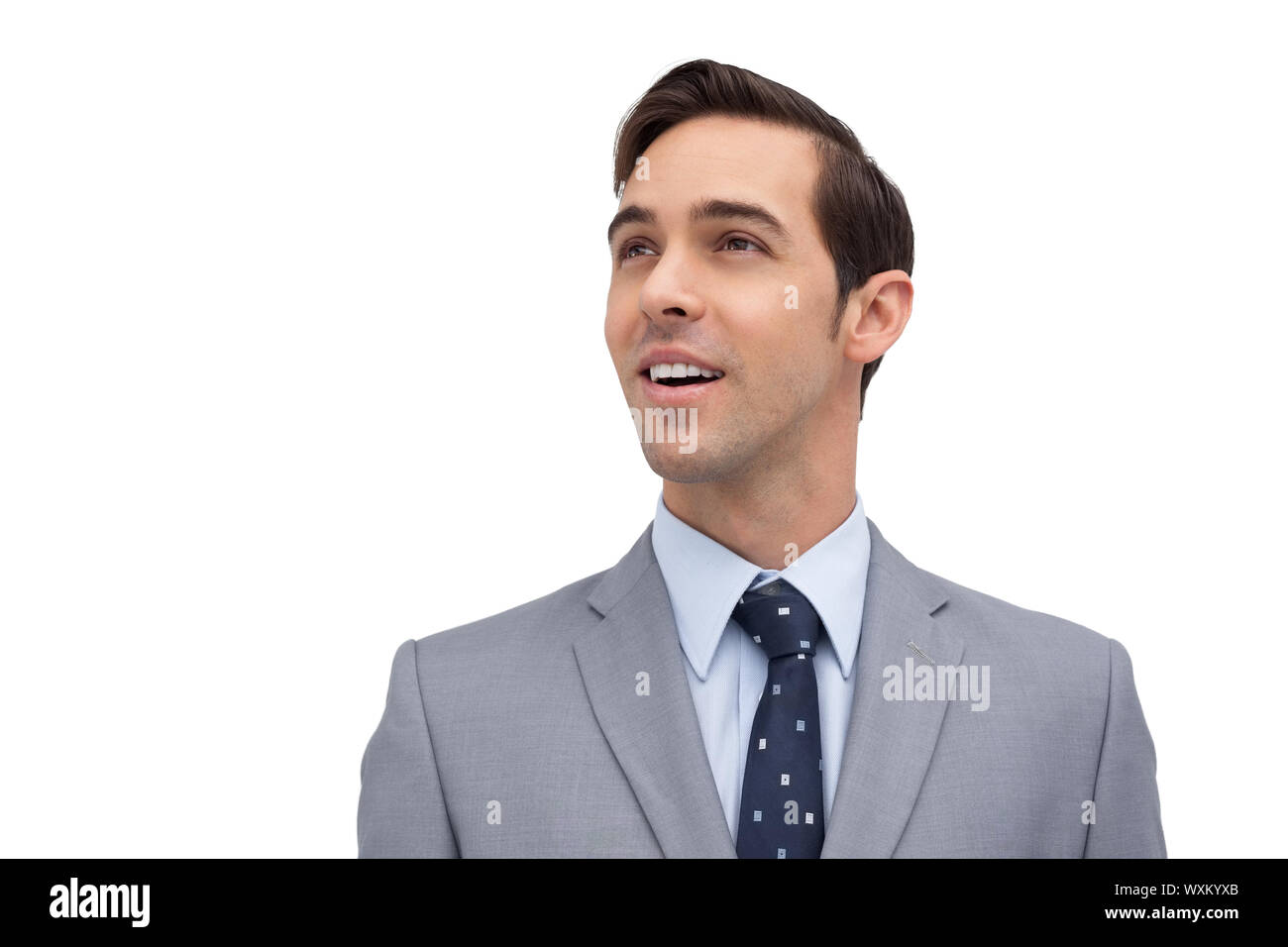 Smiling businessman looking away against white background Stock Photo ...