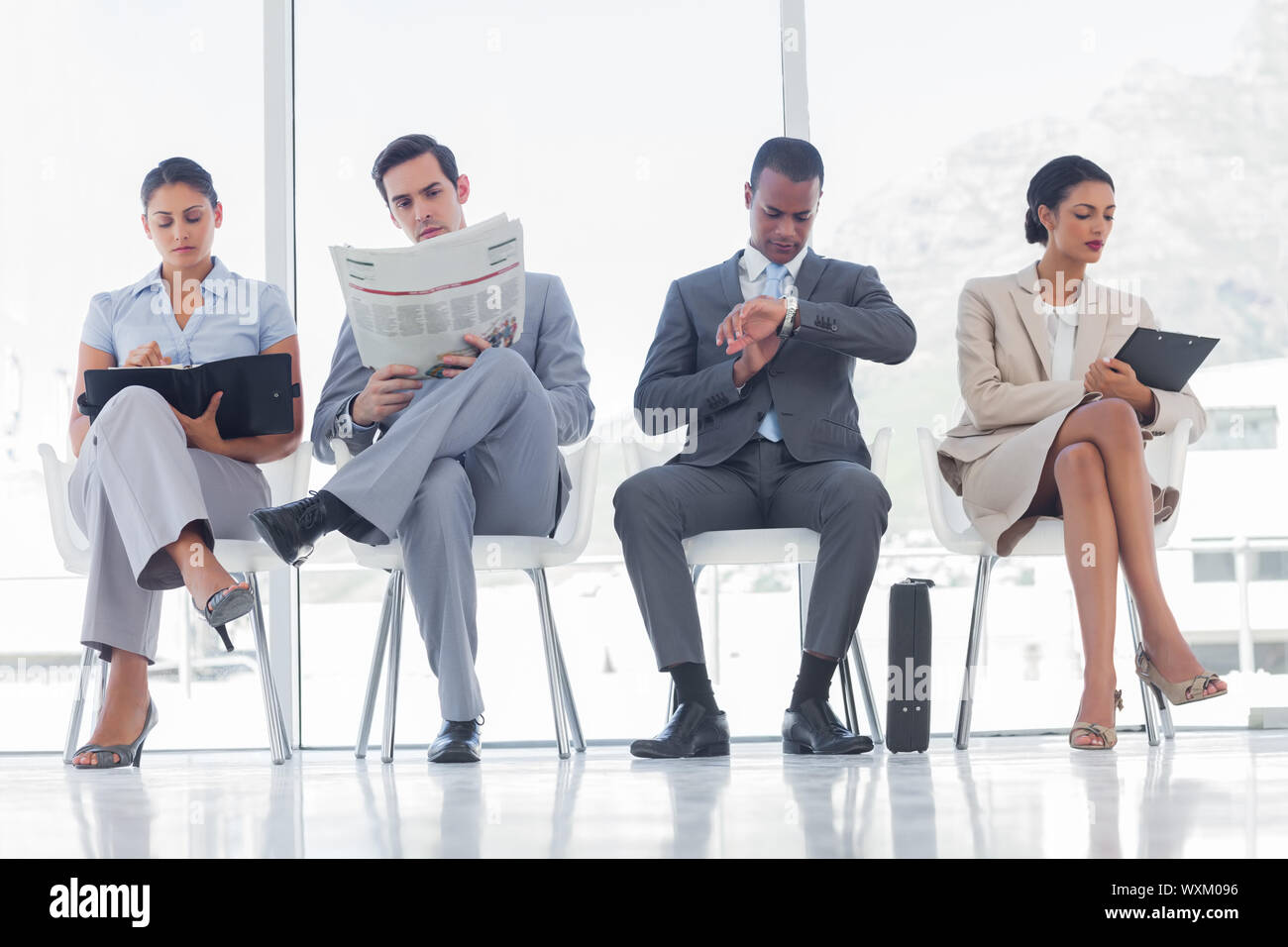 Waiting room with business people sat in line Stock Photo - Alamy