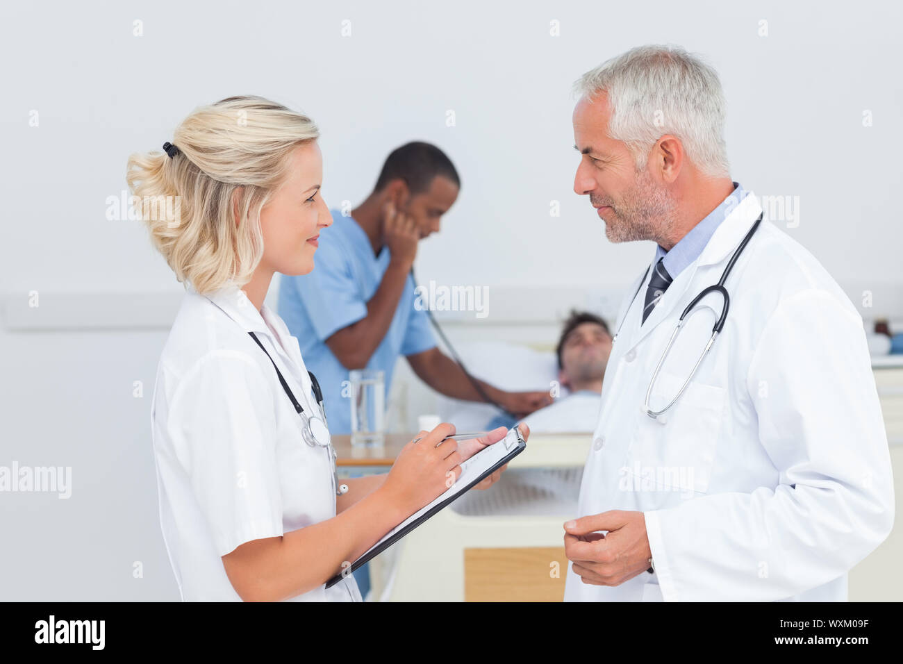 Doctors talking together in front of the patient Stock Photo - Alamy
