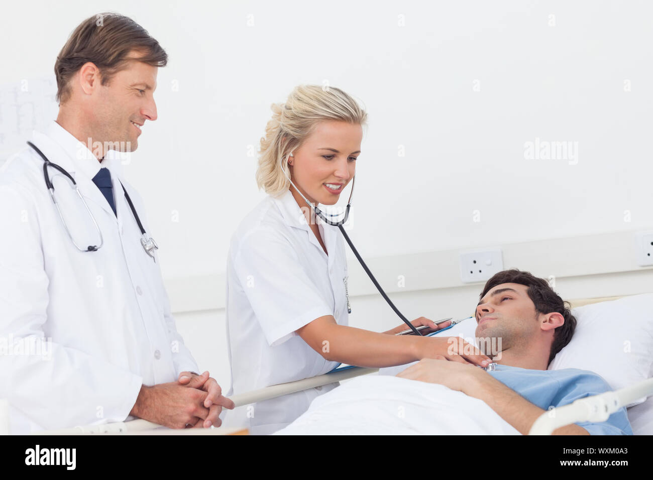 Woman doctor taking the heartbeat of her patient Stock Photo - Alamy